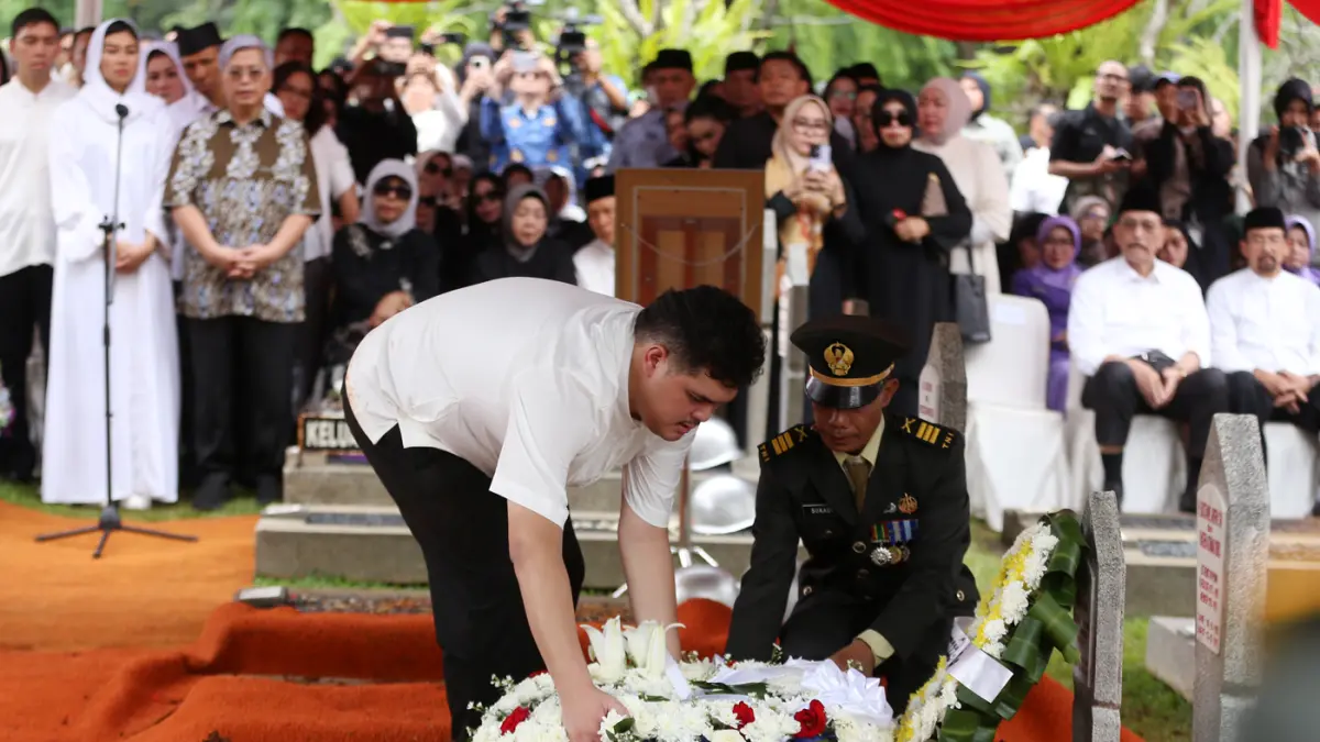 Keluarga dan krabat meletakkan karangan bunga saat upacara pemakaman ...